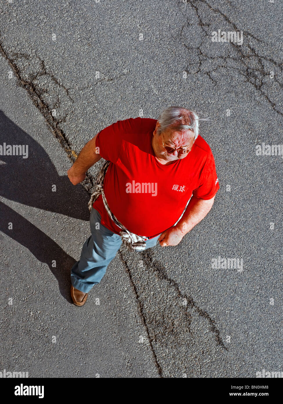 Overweight man walking across road / overhead view - France Stock Photo ...