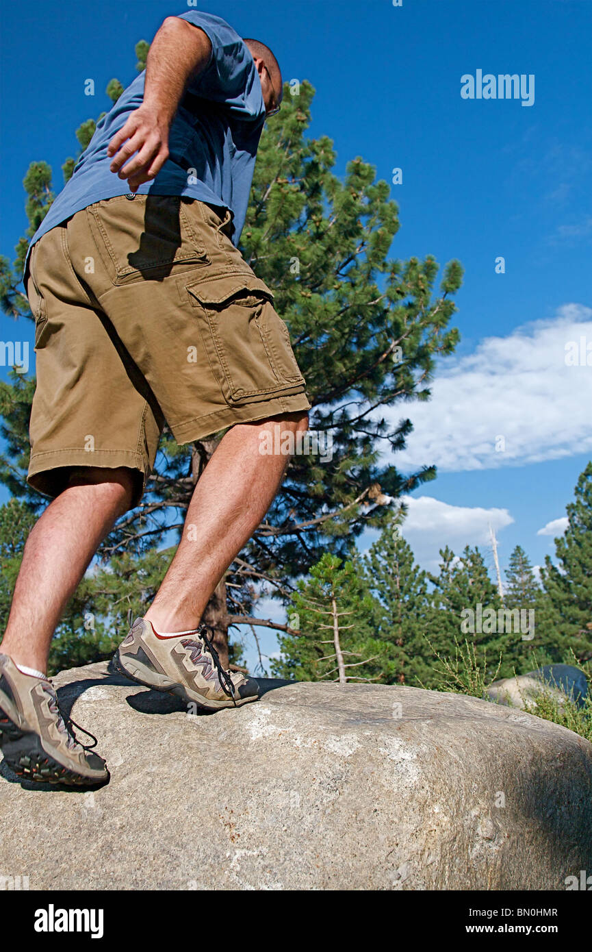 Trail runner climbing a steep rock in his path Stock Photo - Alamy