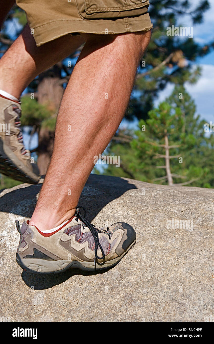 Trail runner climbing a steep rock in his path Stock Photo - Alamy