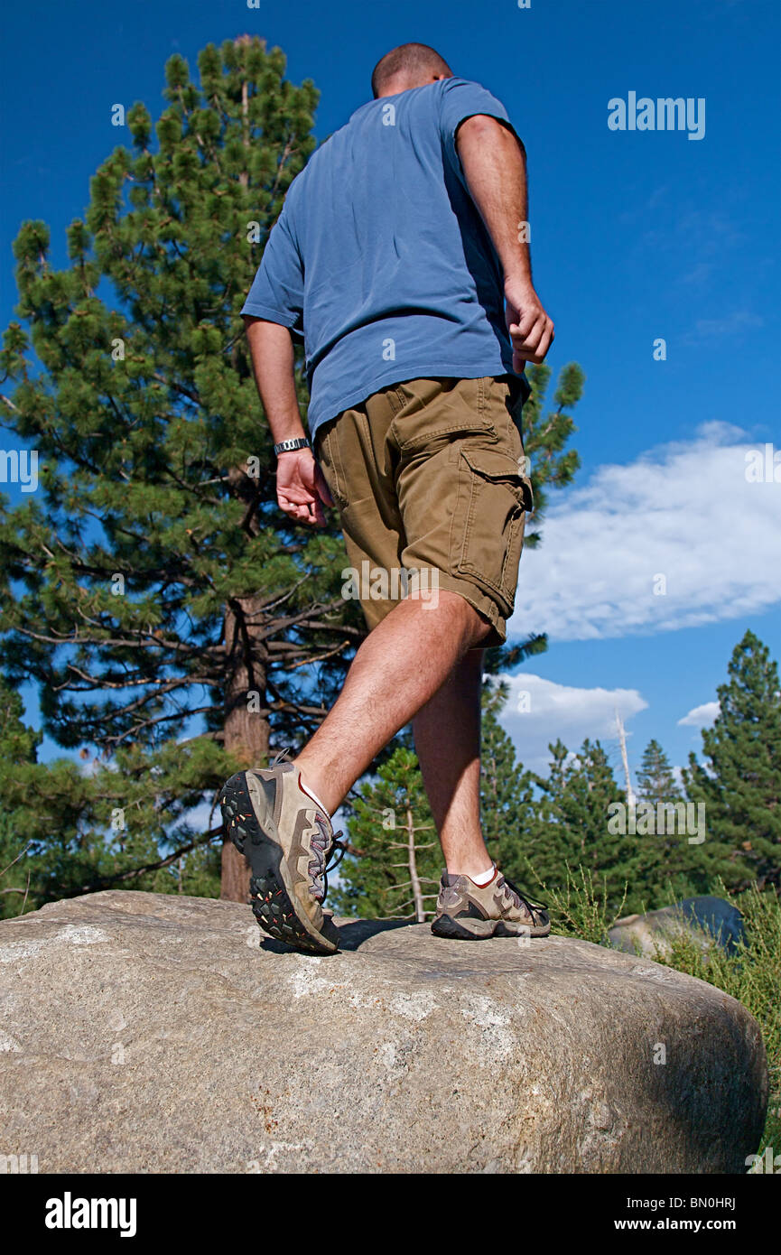 Trail runner climbing a steep rock in his path Stock Photo - Alamy
