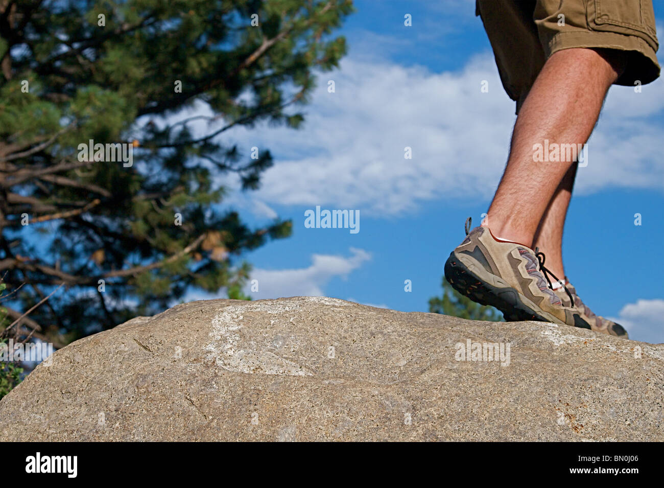 Trail runner climbing a steep rock in his path Stock Photo - Alamy