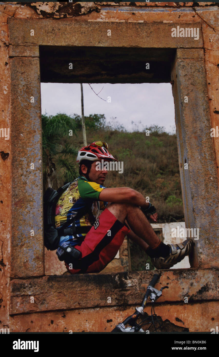 Cyclist resting in an old window frame in Brazil Stock Photo - Alamy