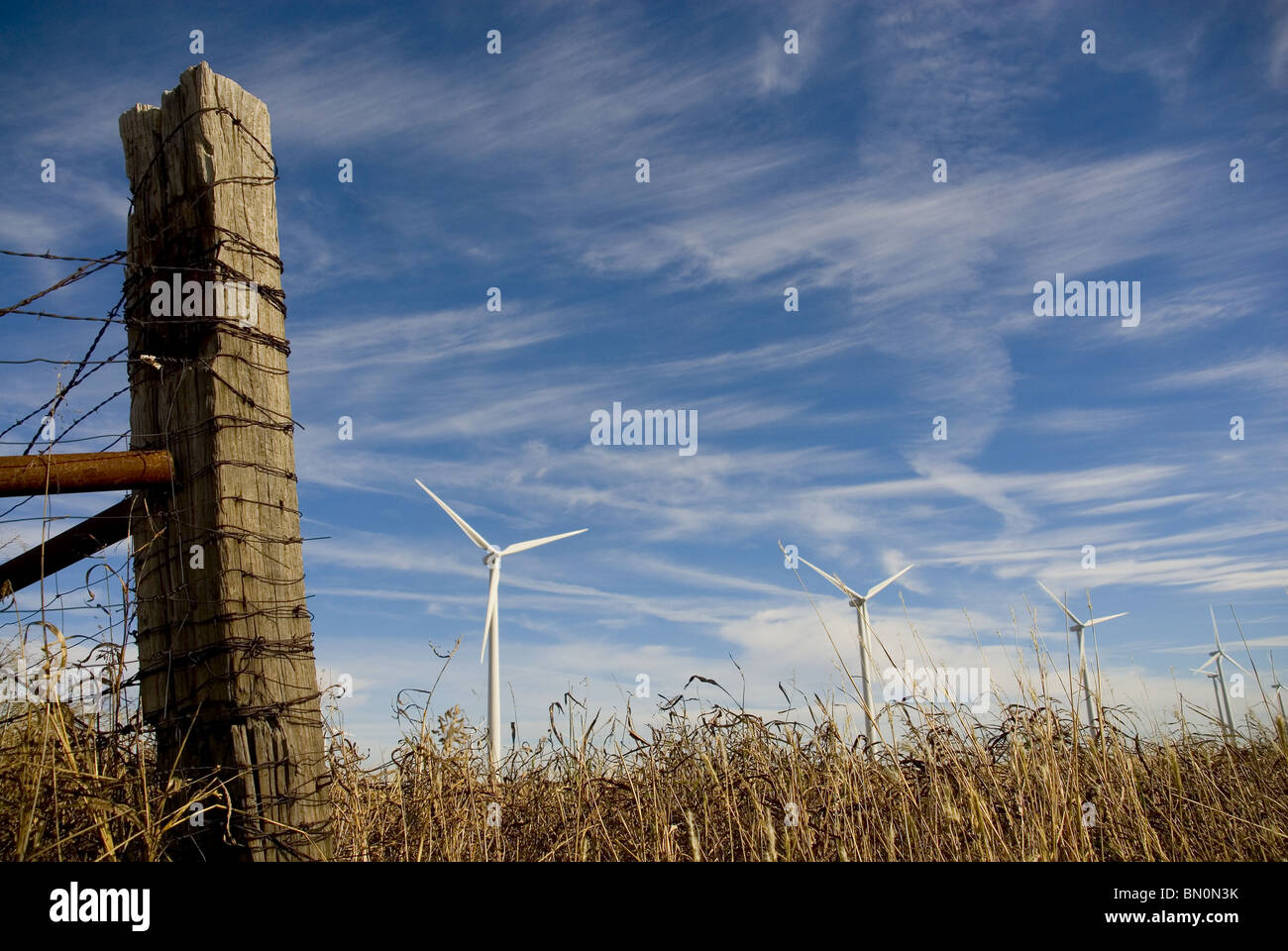 Barbed Wire Wrapped Fence Post and Wind Turbines Stock Photo - Alamy