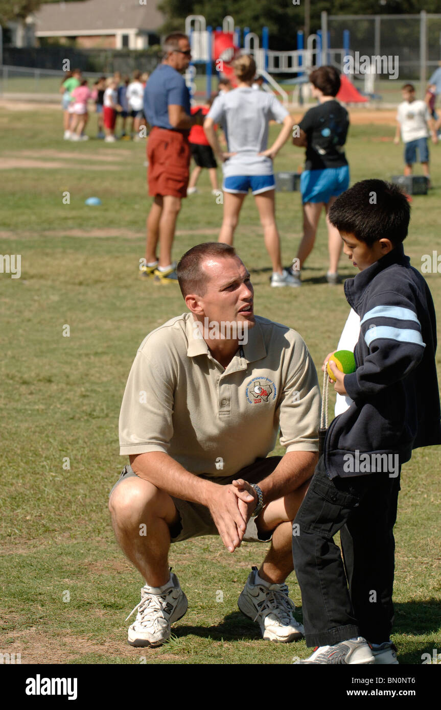 Male student teacher talks to male student during recess at Great Oaks ...