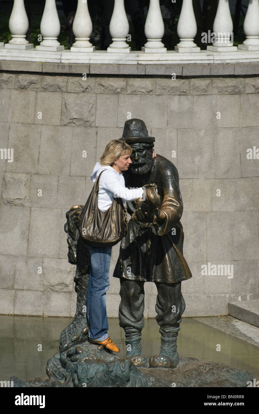 Russian young girl posing next to the bronze statue of Russian fairy ...