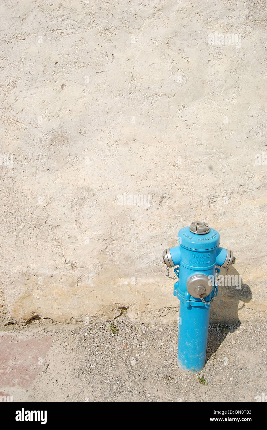 A light blue fire hydrant against a wall Stock Photo - Alamy