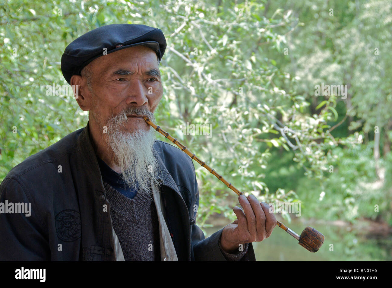 Portrait bearded man smoking bamboo pipe Shiguzhen Yunnan China Stock ...