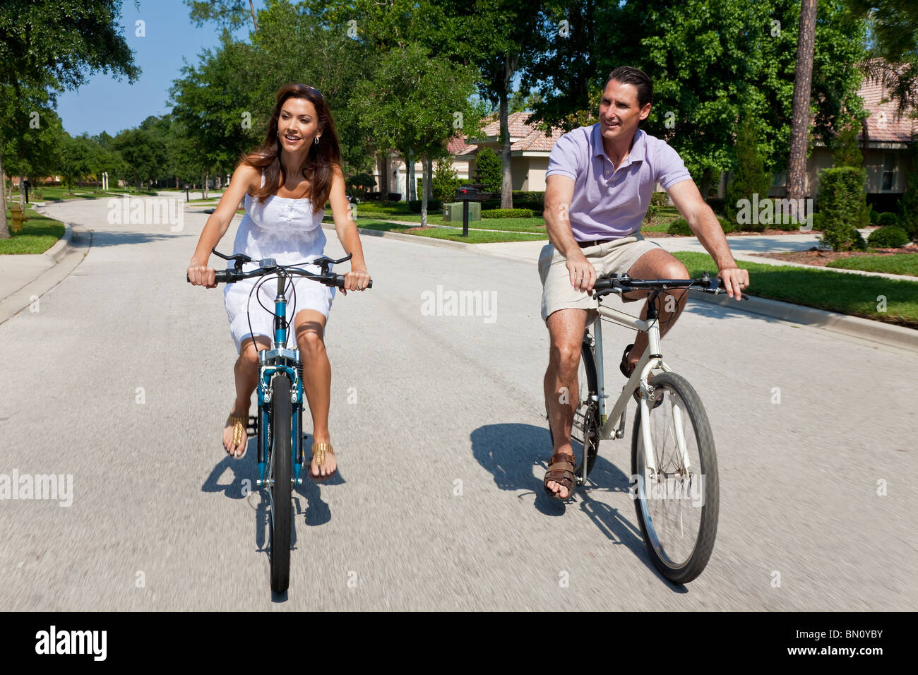 Two attractive adults, man and woman couple, cycling together, shot ...