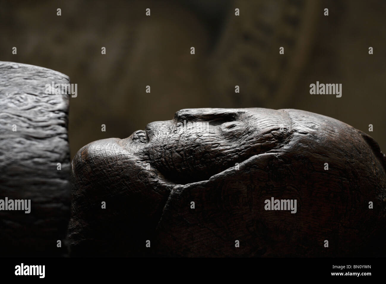 A wooden effigy, close up of the head showing the grain of the wood and ...