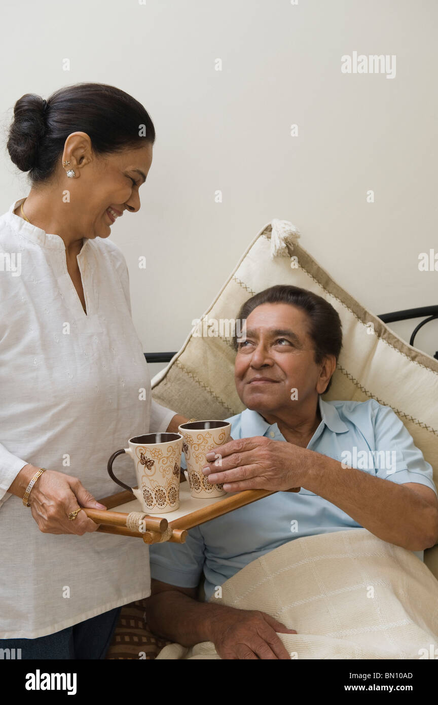 Woman bringing tea for a man Stock Photo - Alamy