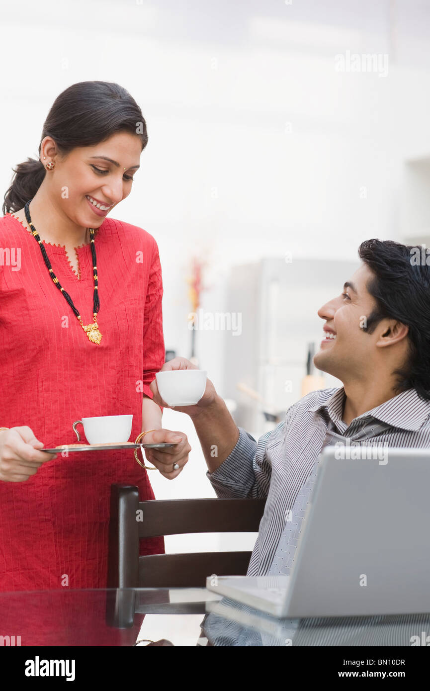 Woman giving tea to her husband Stock Photo - Alamy