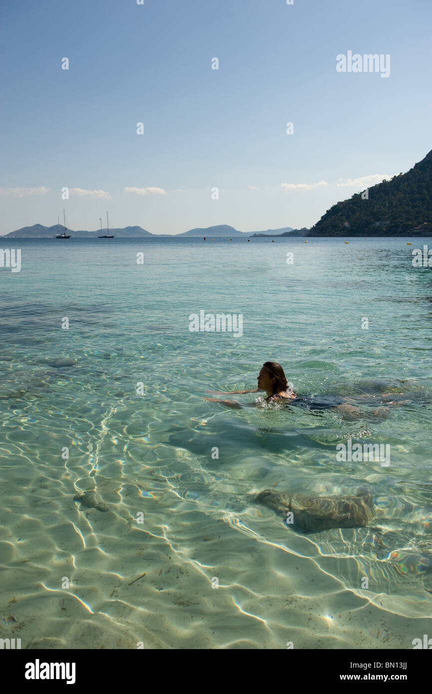 Woman swimming in the crystal clear waters of Formentor bay, Mallorca ...
