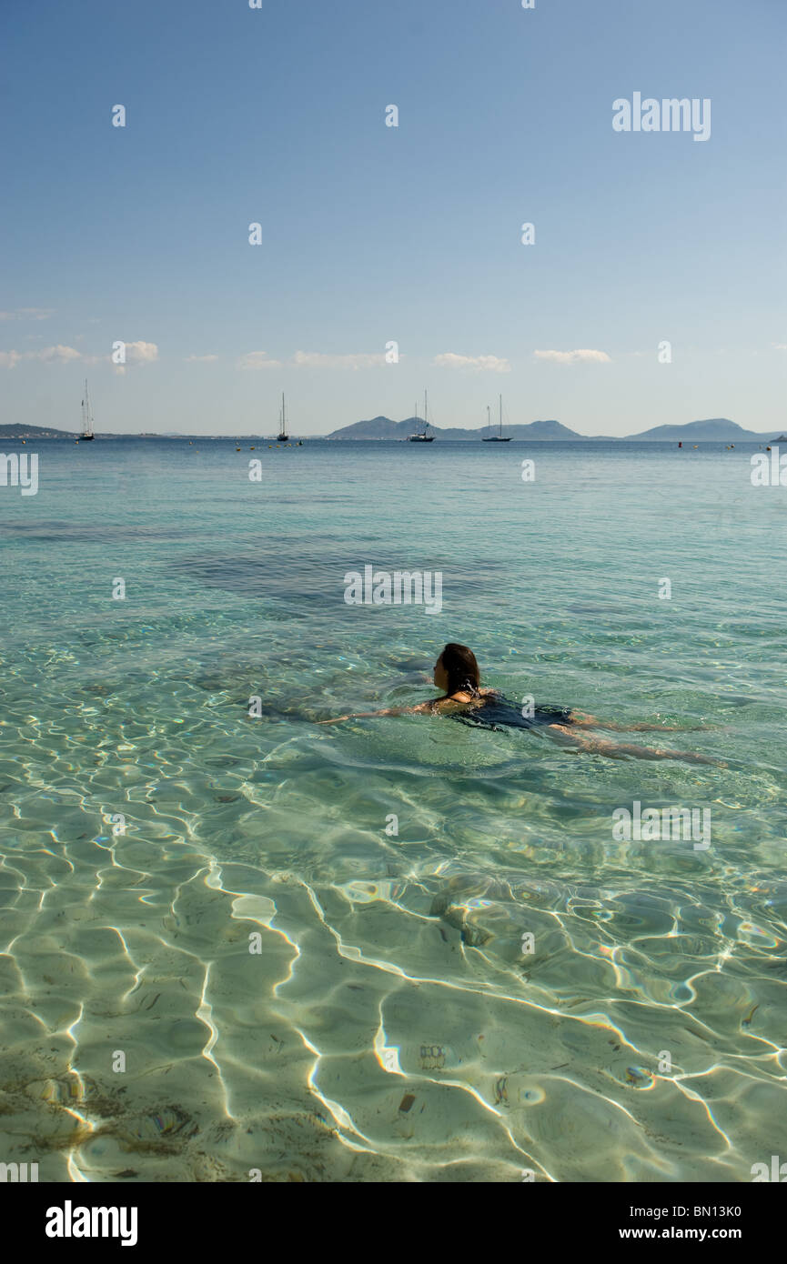 Woman swimming in the crystal clear waters of Formentor bay, Mallorca ...