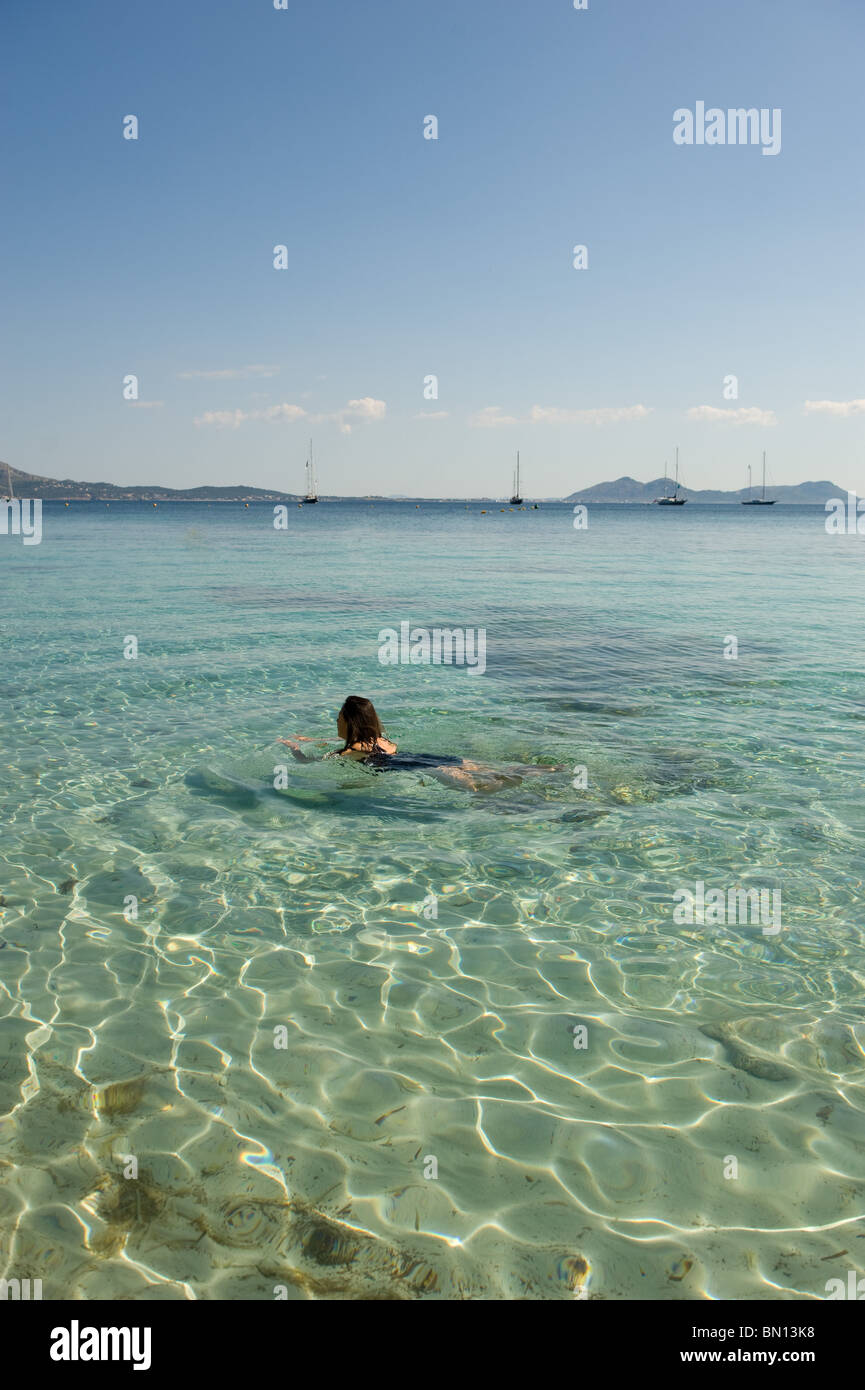 Woman swimming in the crystal clear waters of Formentor bay, Mallorca ...