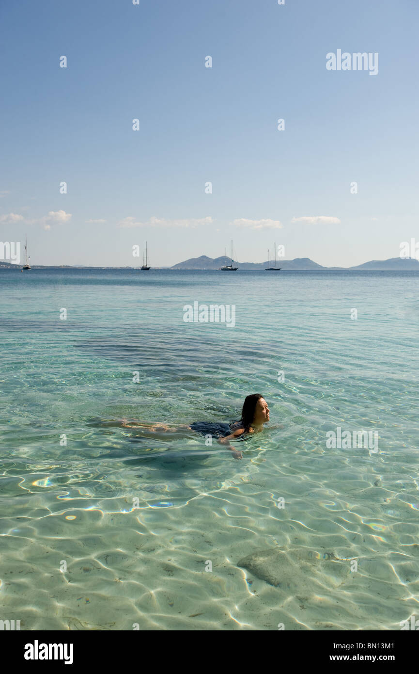 Woman swimming in the crystal clear waters of Formentor bay, Mallorca ...