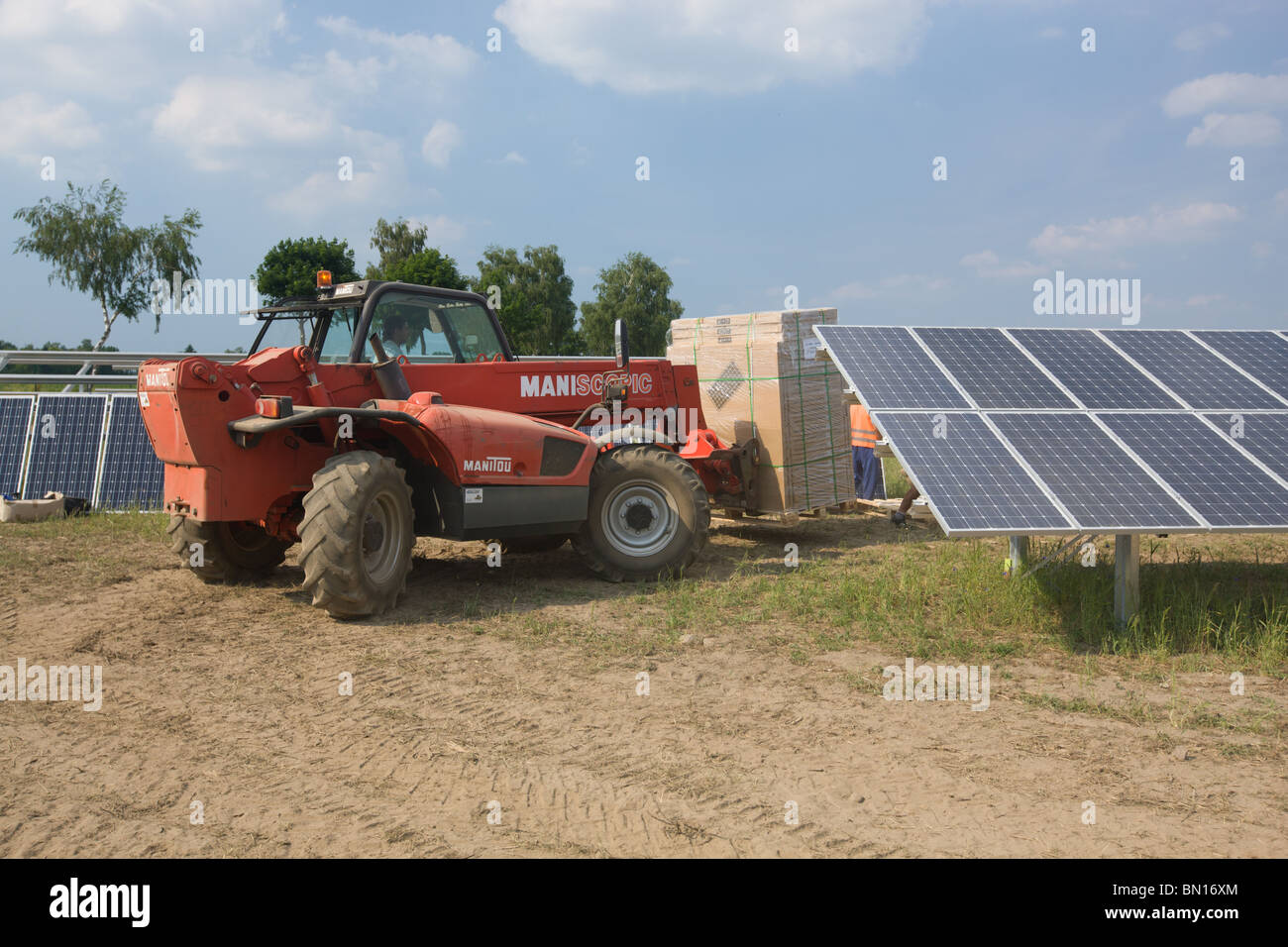 telescopic handler carrying pallet with solar modules at a construction ...