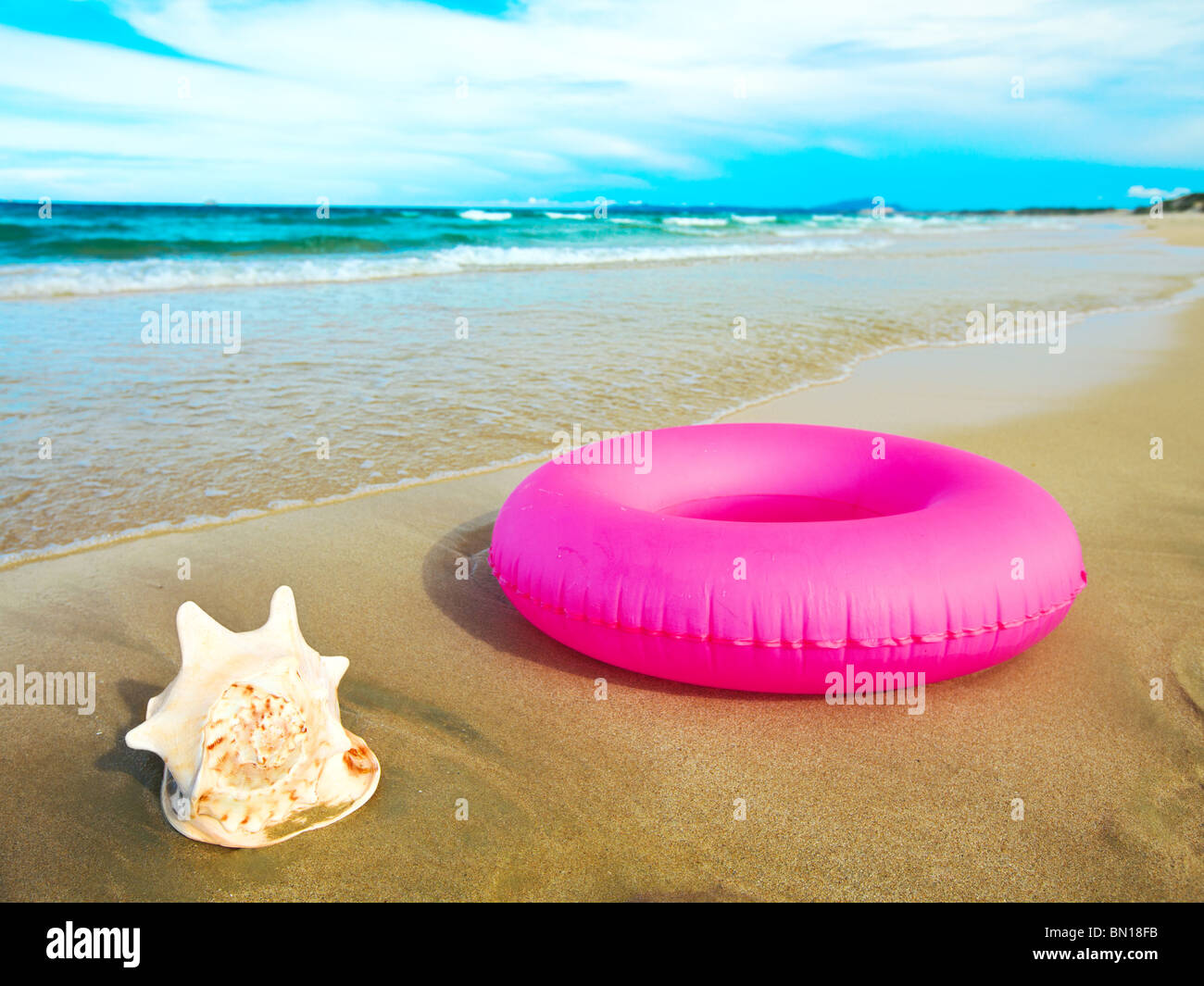 Seashell and inflatable tube on the beach Stock Photo - Alamy