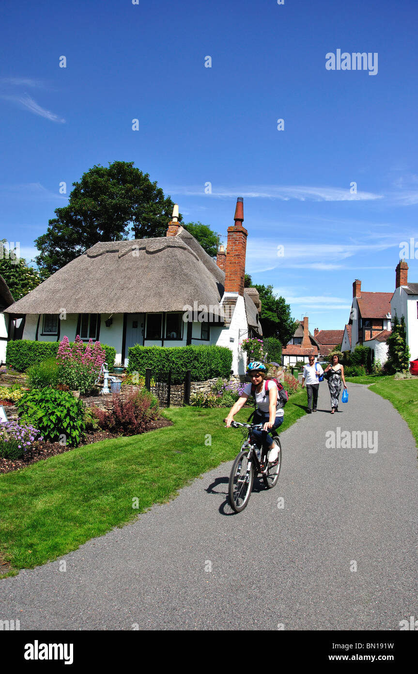 Woman cycling through village, Welford-on-Avon, Warwickshire, England ...
