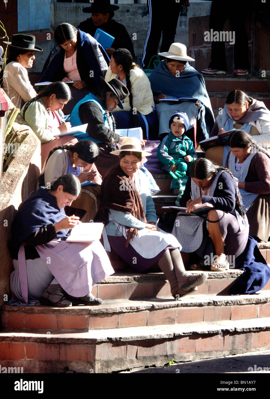 A group of women study while sitting on steps in the sunshine in Sucre ...