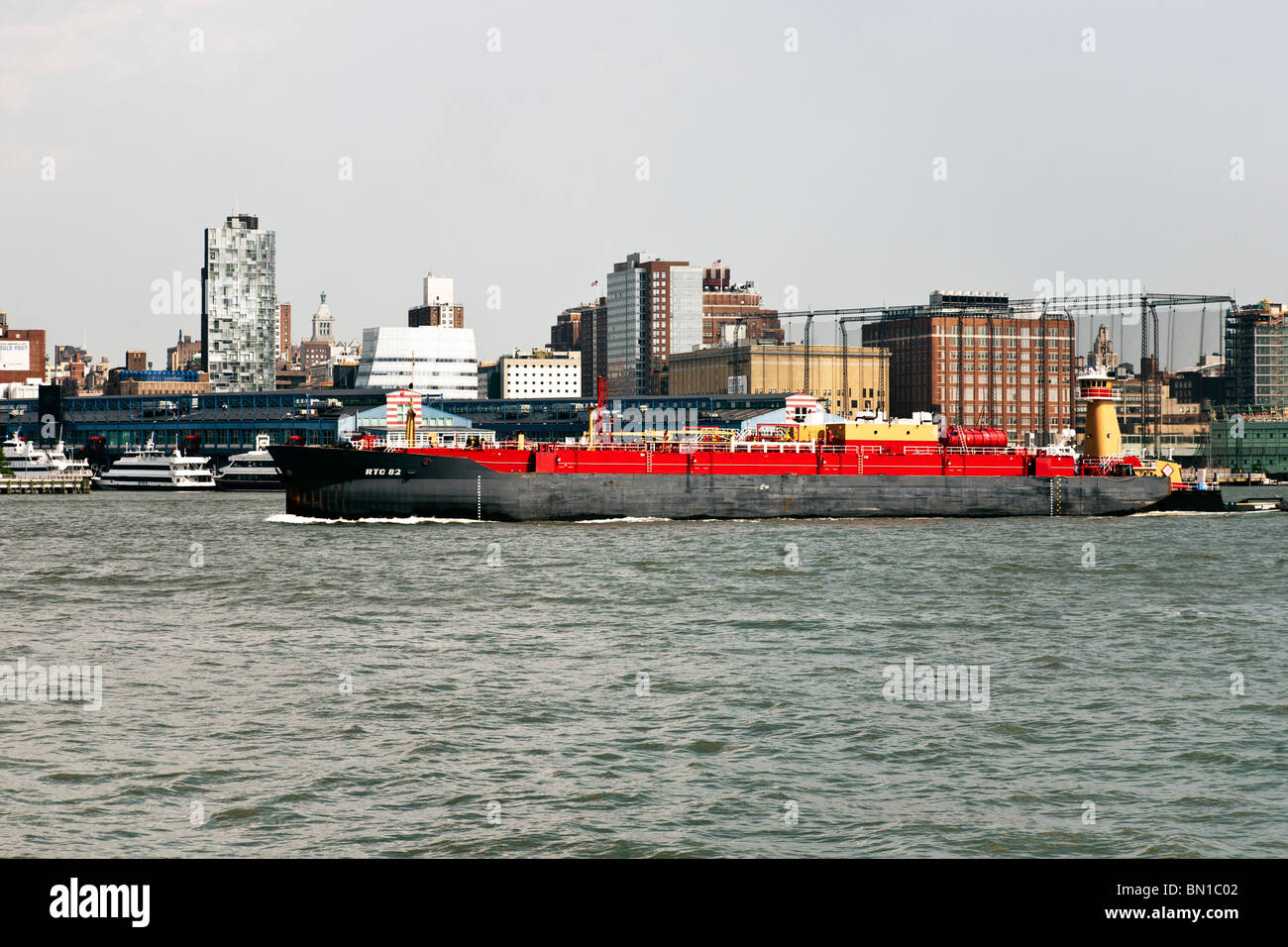 view from water of ocean going fuel tank barge moving up river past ...