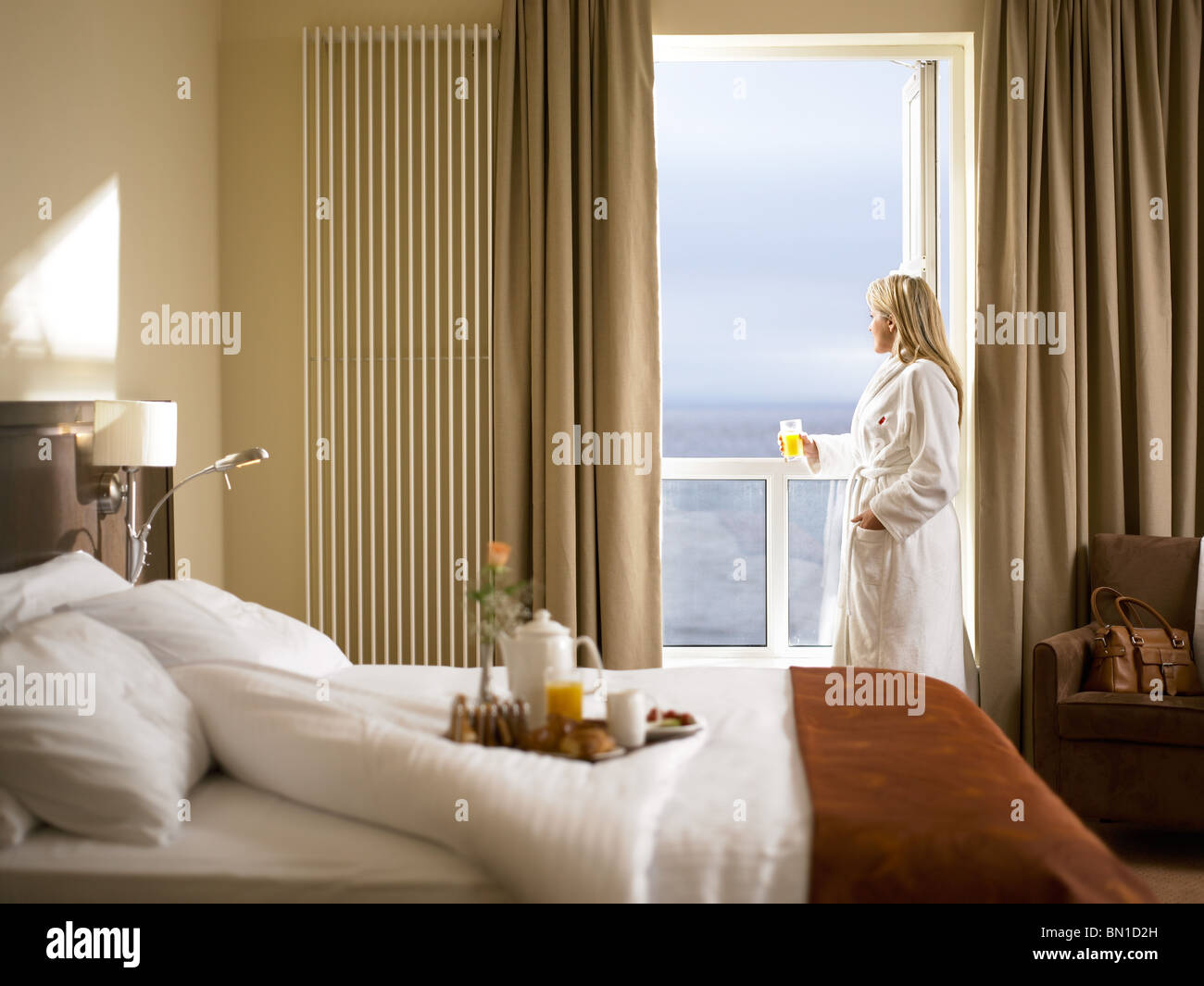 Girl looking out at the sea view from her hotel bedroom window Stock ...