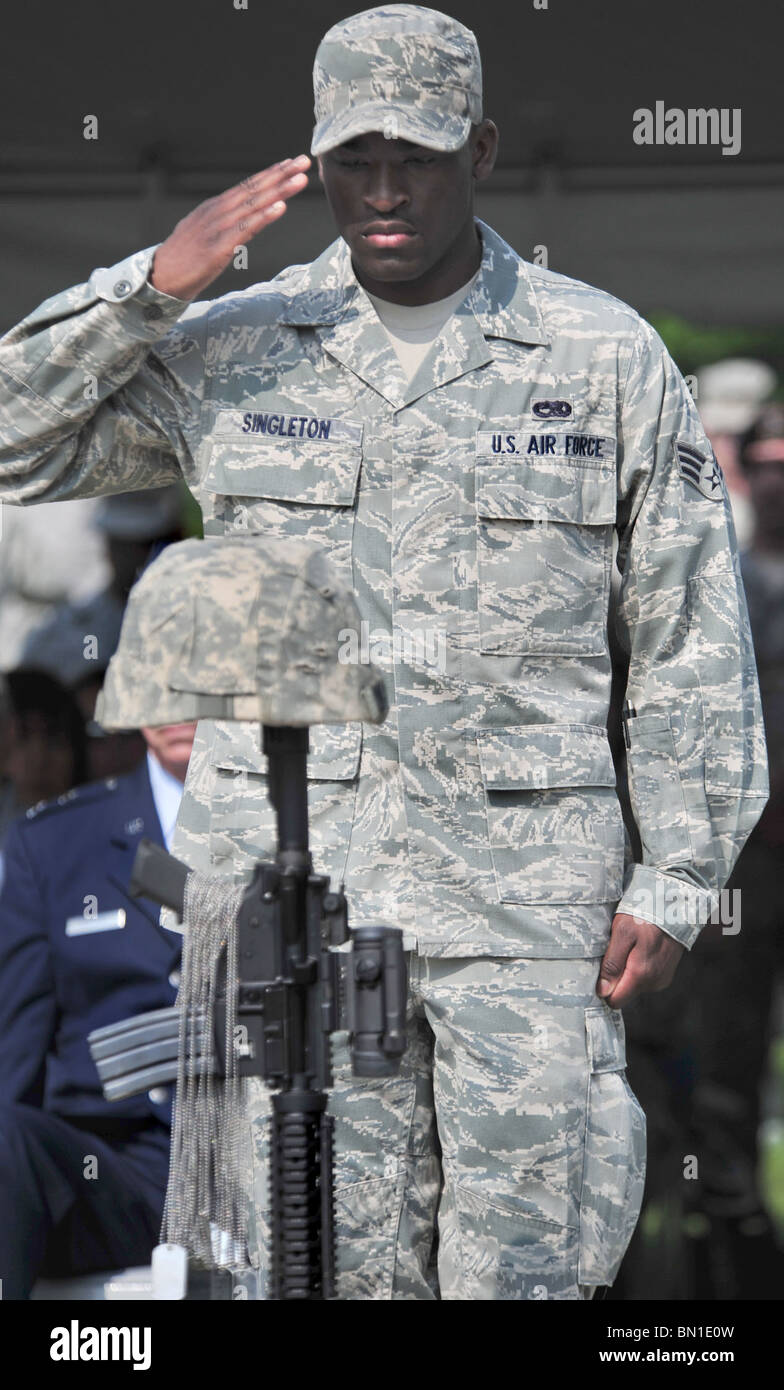 Senior Airman Singleton salutes the battle field cross after placing ...
