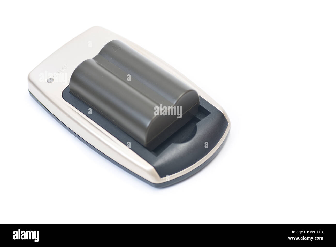 A small camera battery on its charger, isolated on white Stock Photo ...