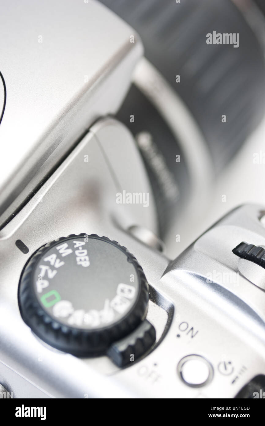 A closeup of the dial on the top of an SLR camera, with the lens ...