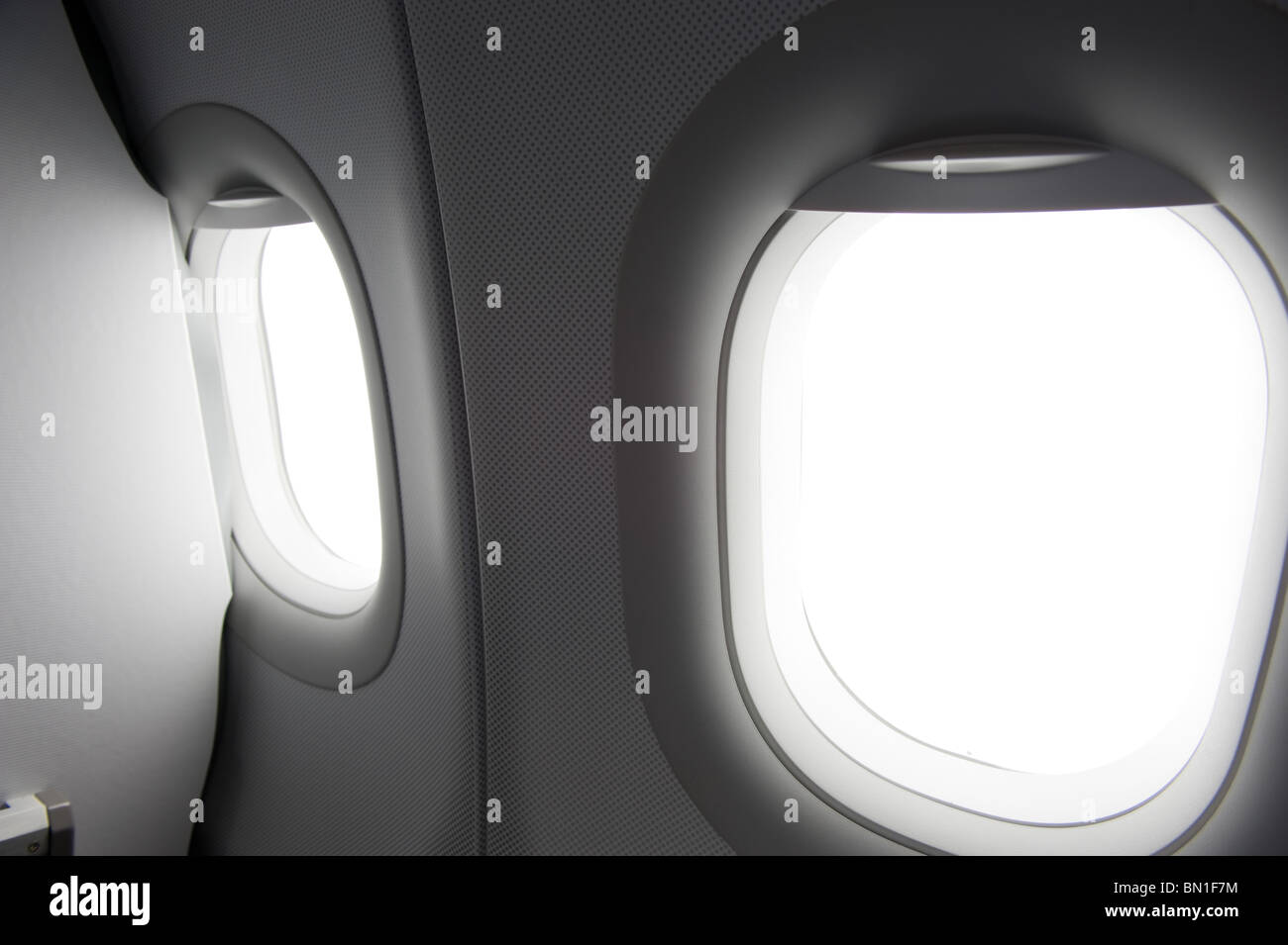 The window of a passenger aircraft with just white visible through it ...