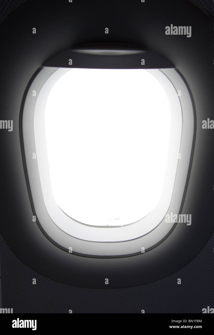 The window of a passenger aircraft with just white visible through it ...