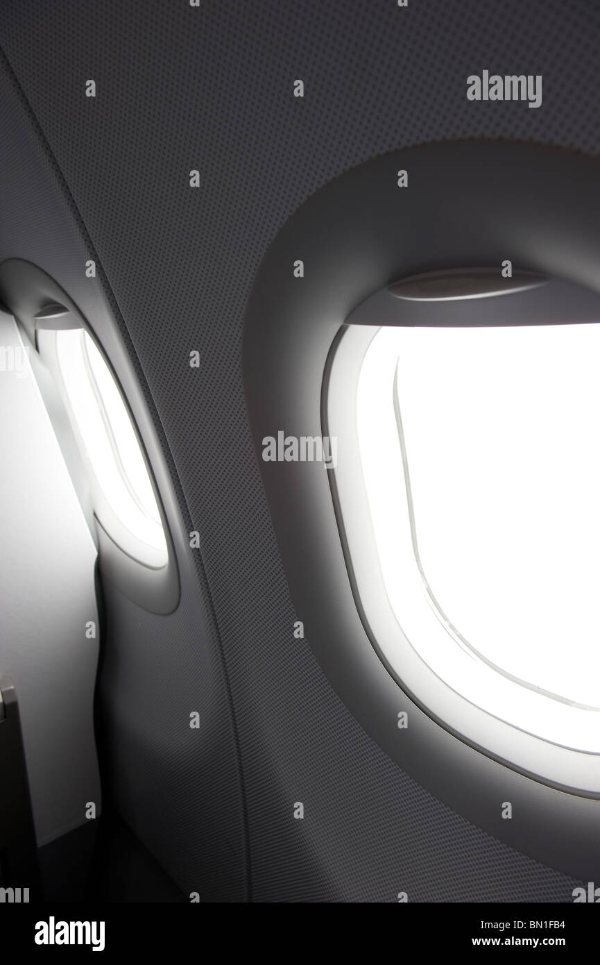 The window of a passenger aircraft with just white visible through it ...