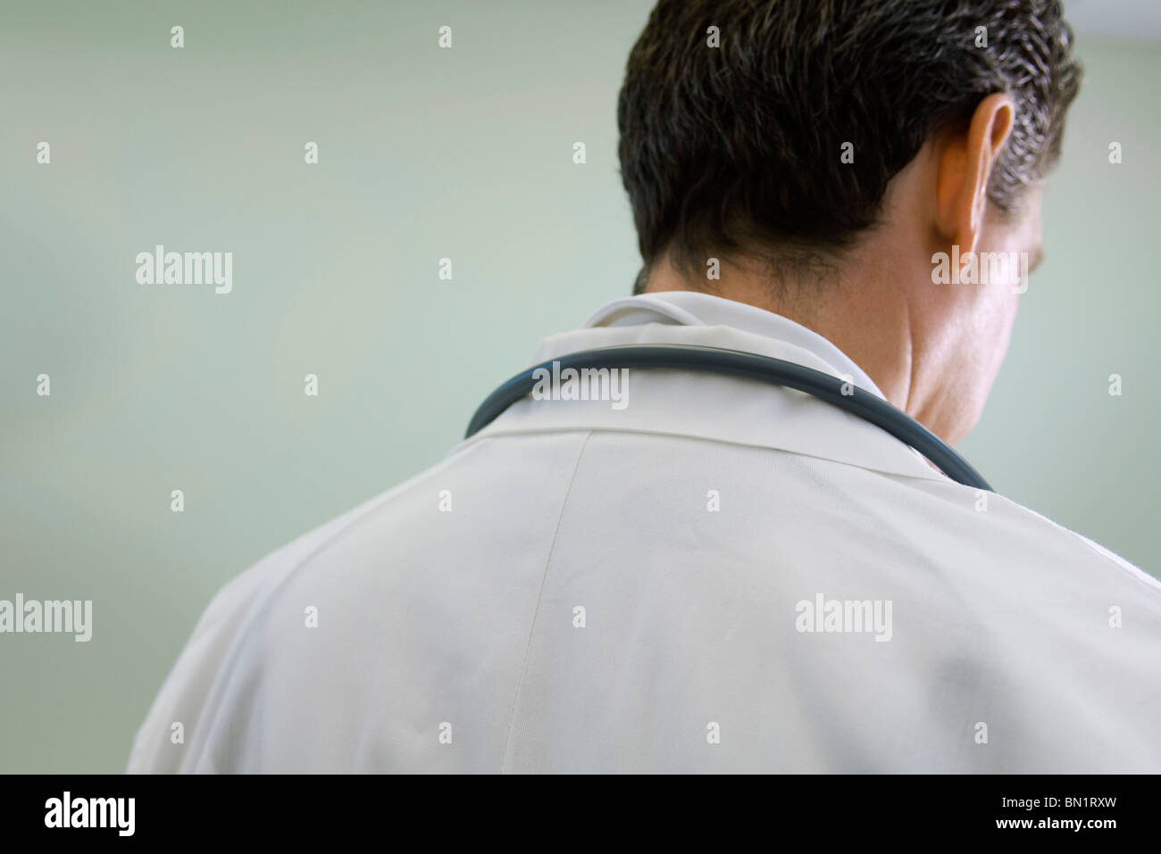 Doctor contemplatively looking down Stock Photo - Alamy