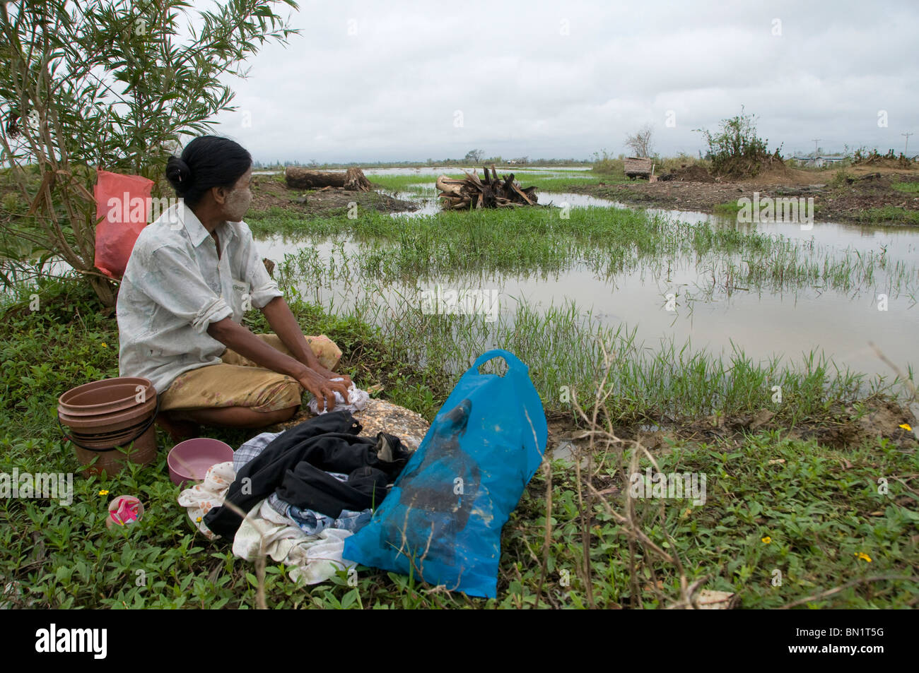 A villager surveys the devastation done by Cyclone Nargis as she washes ...