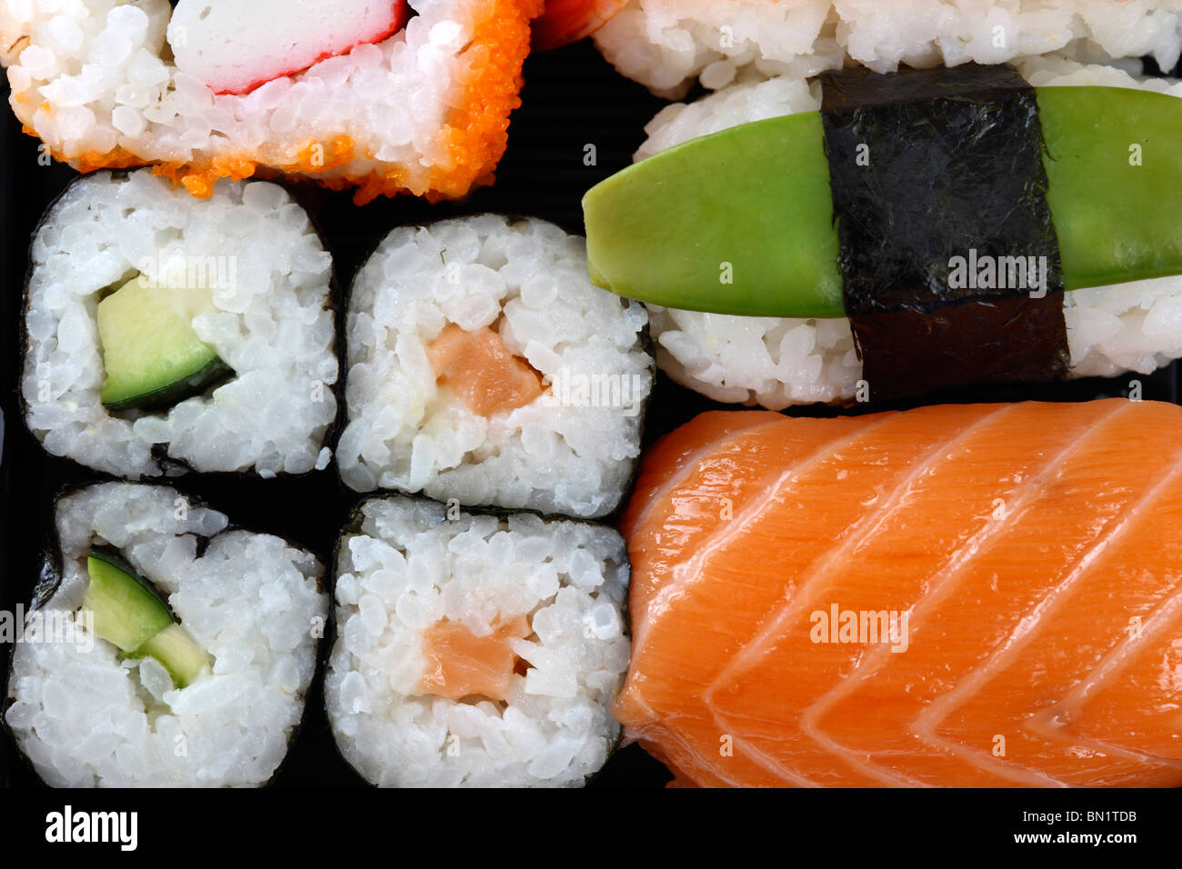 Different sushi and sashimi pieces in a box, for take away, in a ...