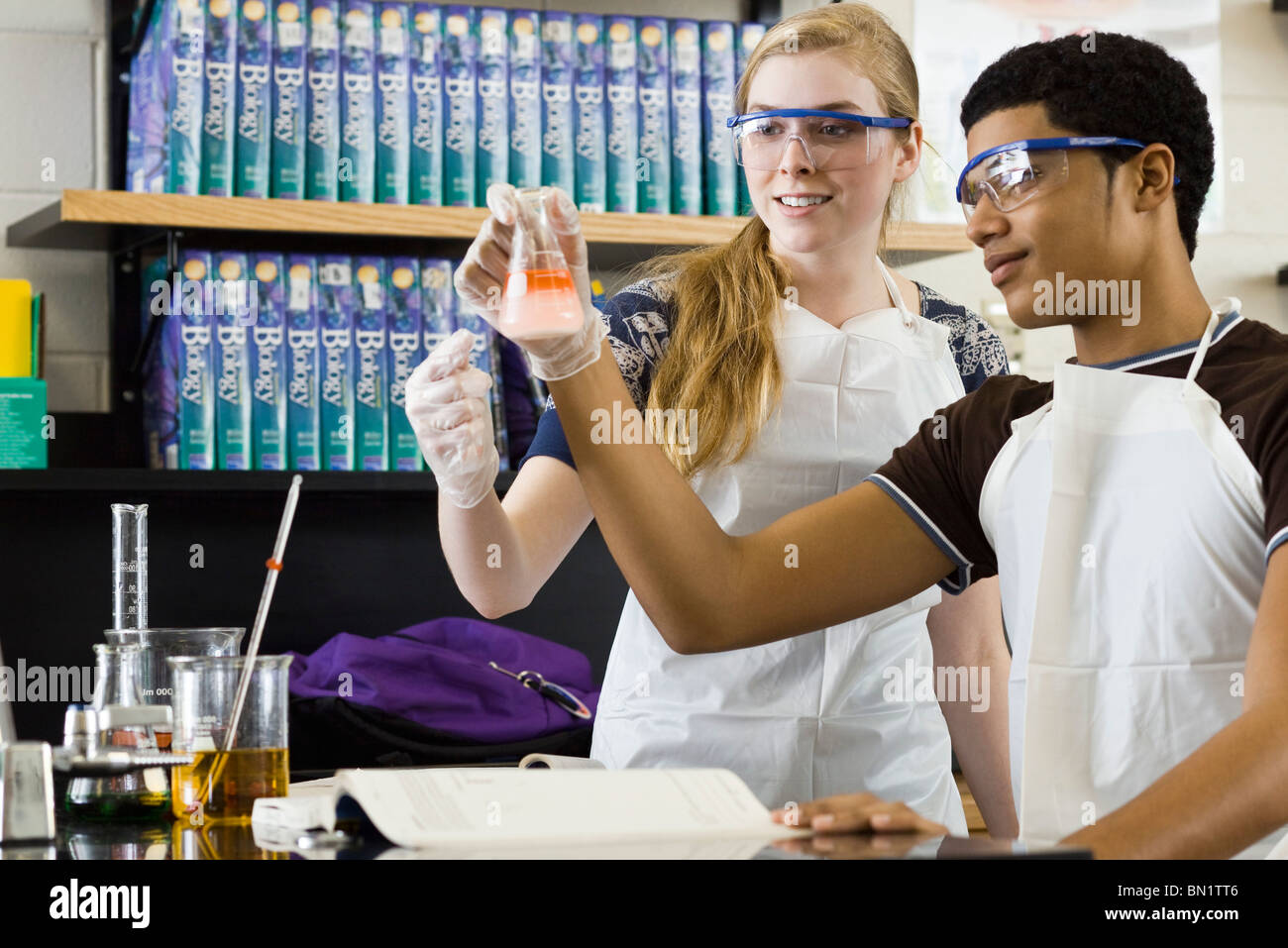 Classmates conducting experiment in chemistry class Stock Photo - Alamy