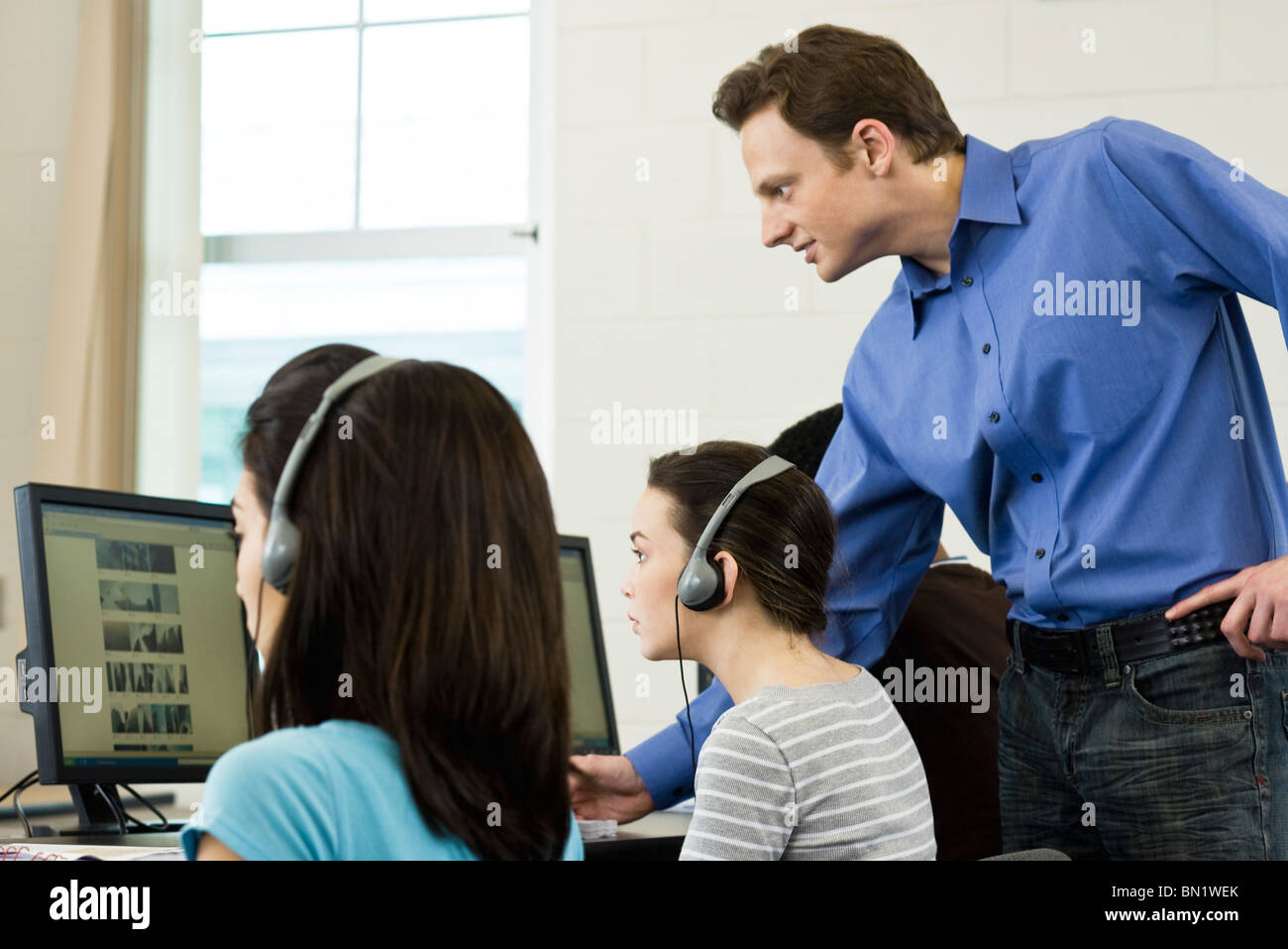 Teacher assisting high school students in computer lab Stock Photo - Alamy