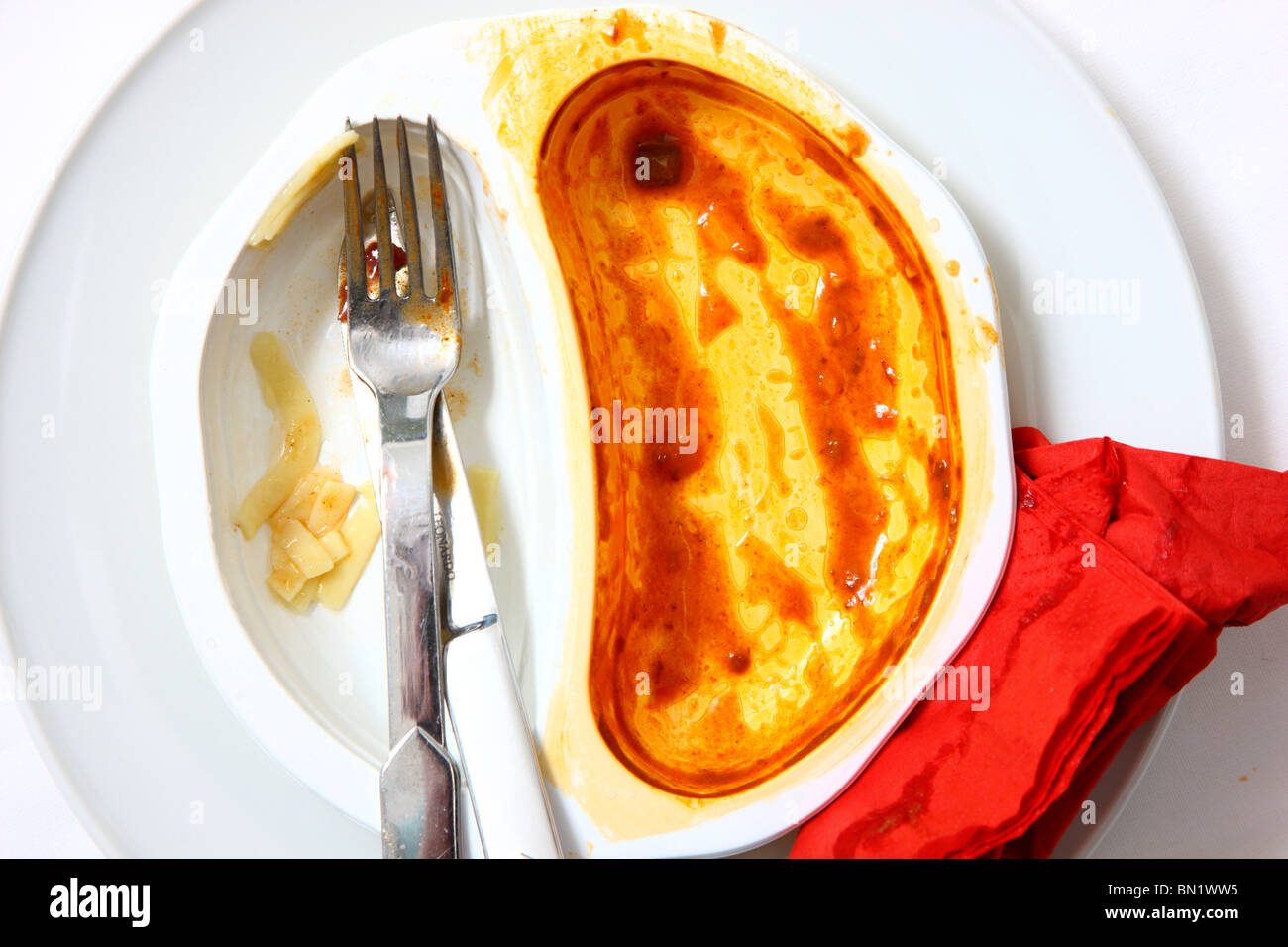 Eaten up remains of a ready-to-serve meal on a plate. Convenience food ...