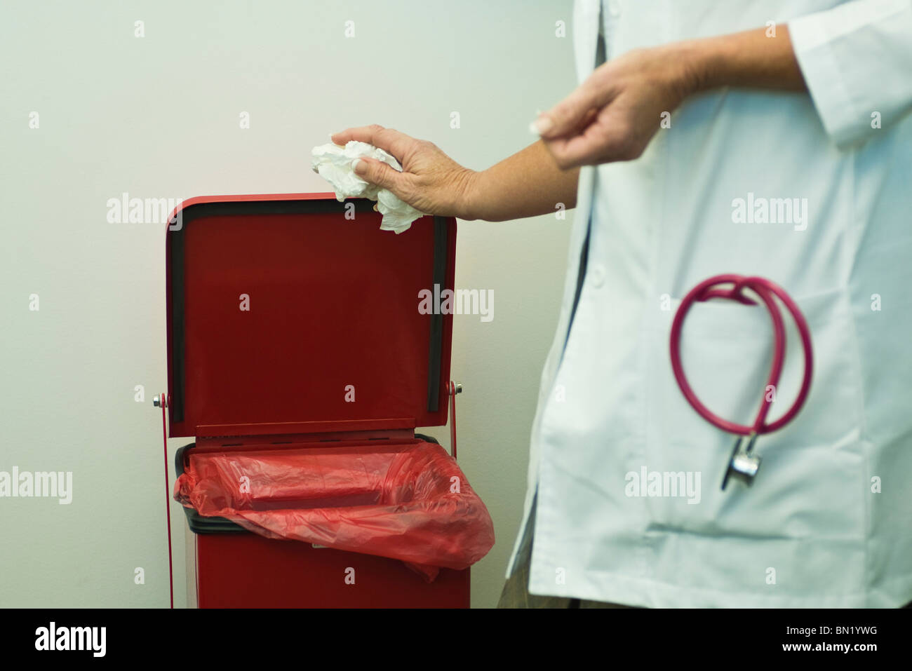 Discarding waste in medical waste bin Stock Photo - Alamy