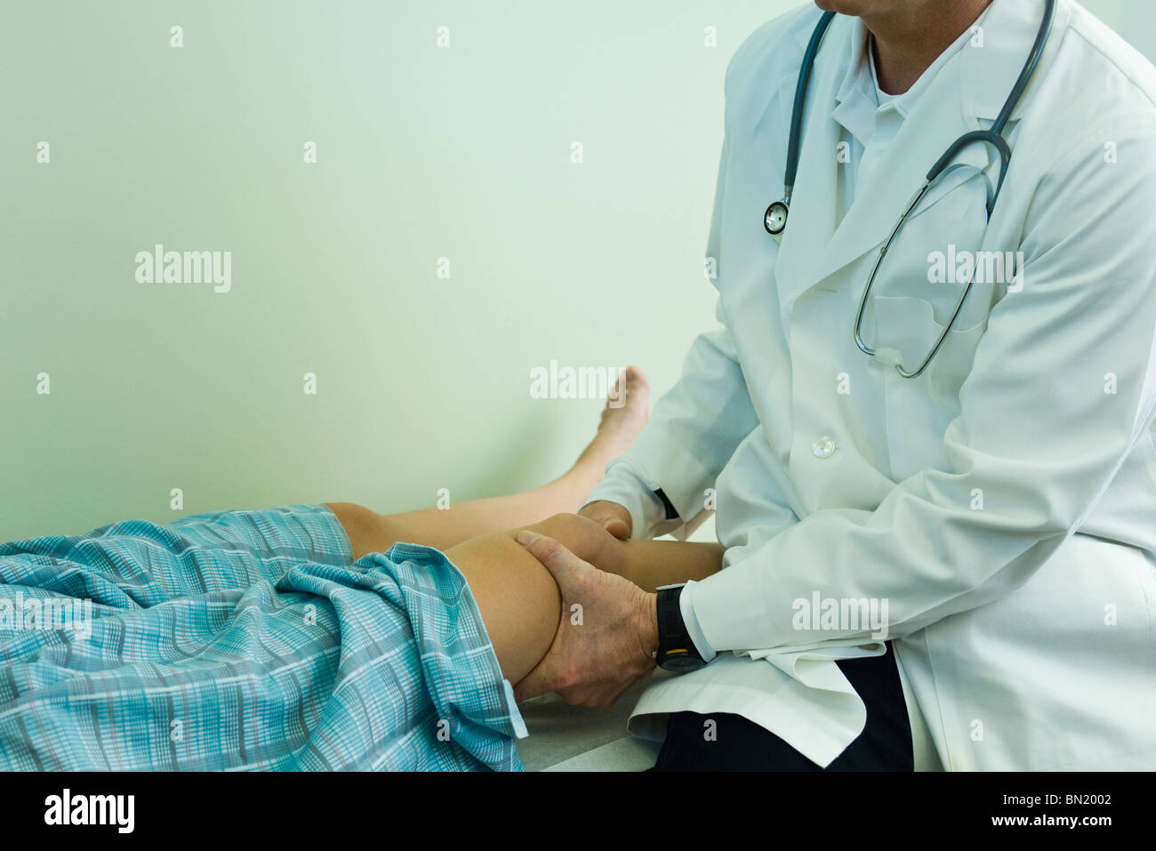 Doctor examining patient's leg Stock Photo - Alamy