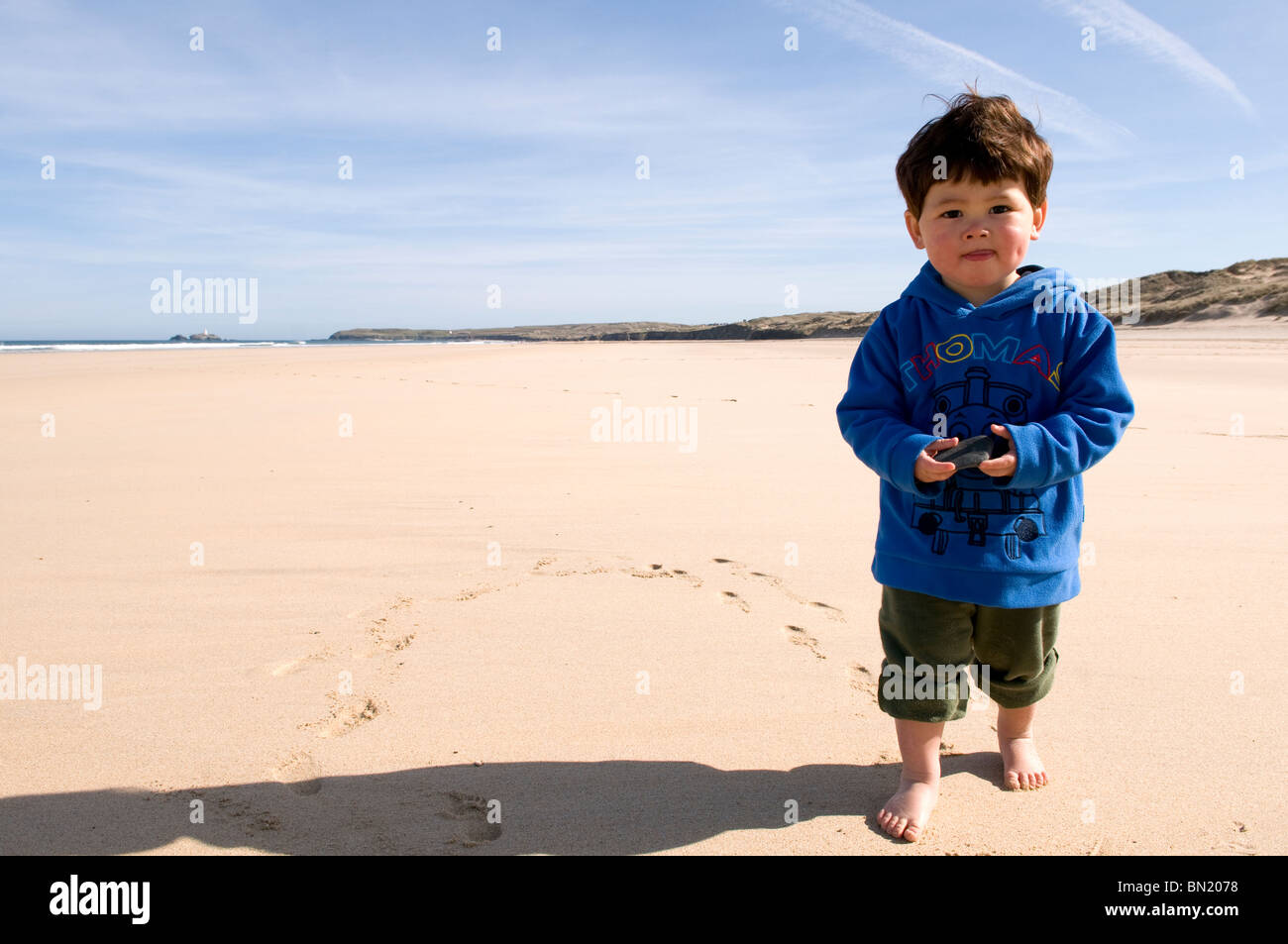 Little boy walking barefoot across a sandy beach Stock Photo - Alamy