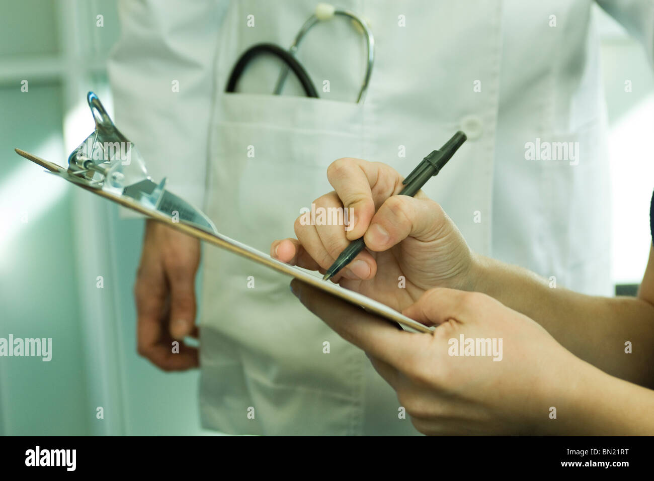 Patient completing medical paperwork Stock Photo - Alamy