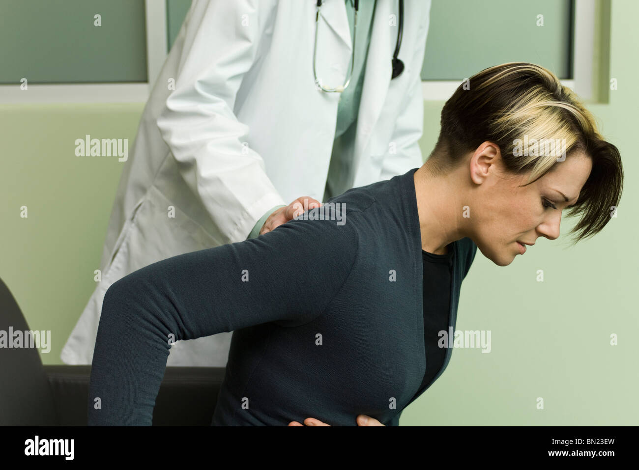 Doctor assisting patient experiencing severe abdominal pain Stock Photo ...