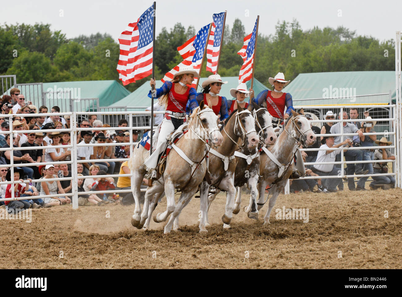 Cowgirls riding horses with US flags at a rodeo parade Stock Photo - Alamy
