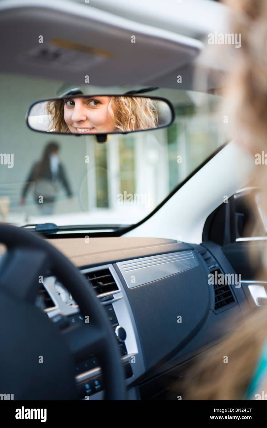 Woman driving, reflection in rearview mirror Stock Photo - Alamy