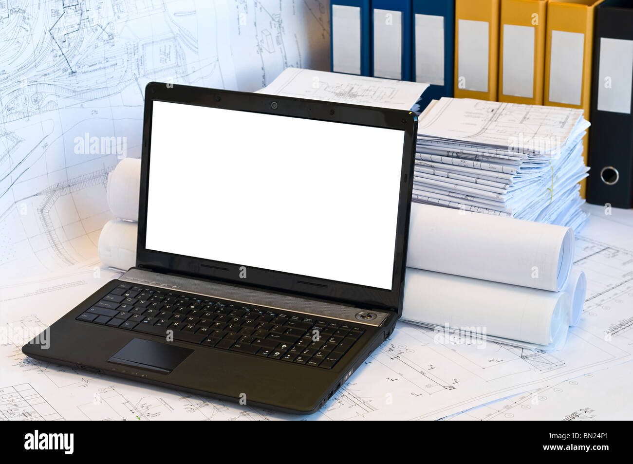 Opened laptop and stack of project drawings. Rolled papers. Working ...