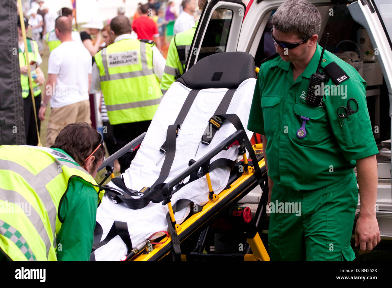 Two paramedics lifting a stretcher in to the back of an ambulance Stock ...