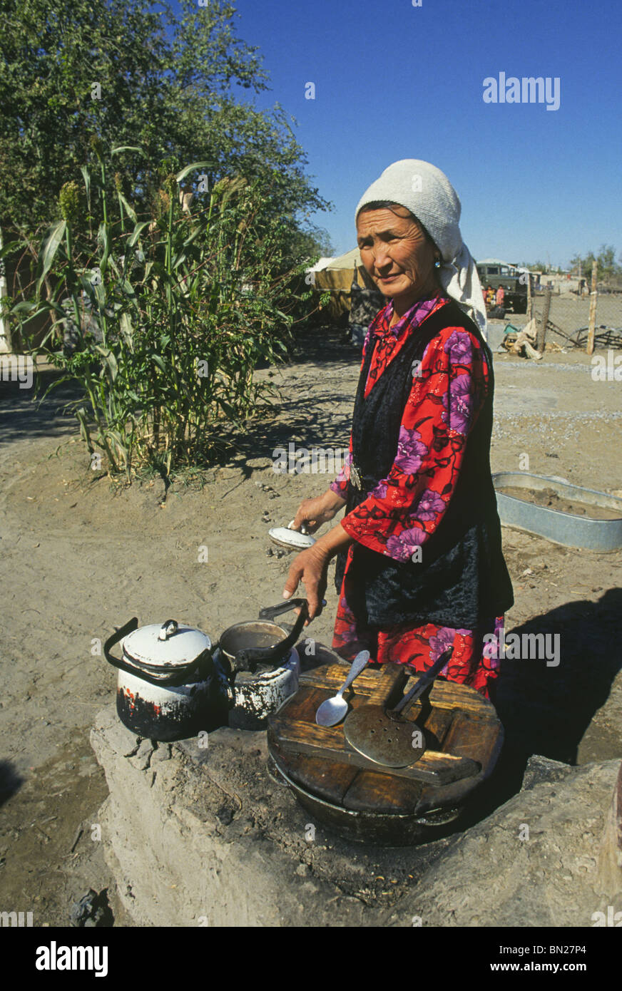 A nomadic Uzbek woman cooks lunch in an outdoor kitchen at her tent ...
