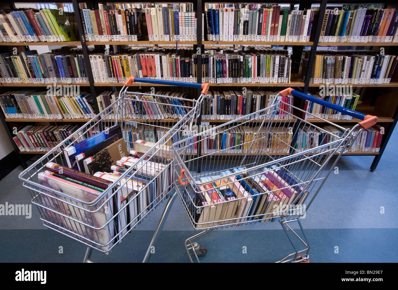Books in a shopping cart in a library Stock Photo - Alamy