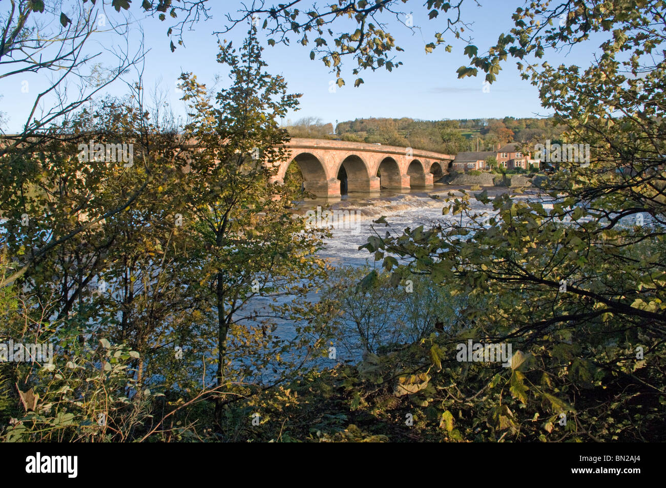 Hexham stone bridge and weir from south side of river downstream with ...