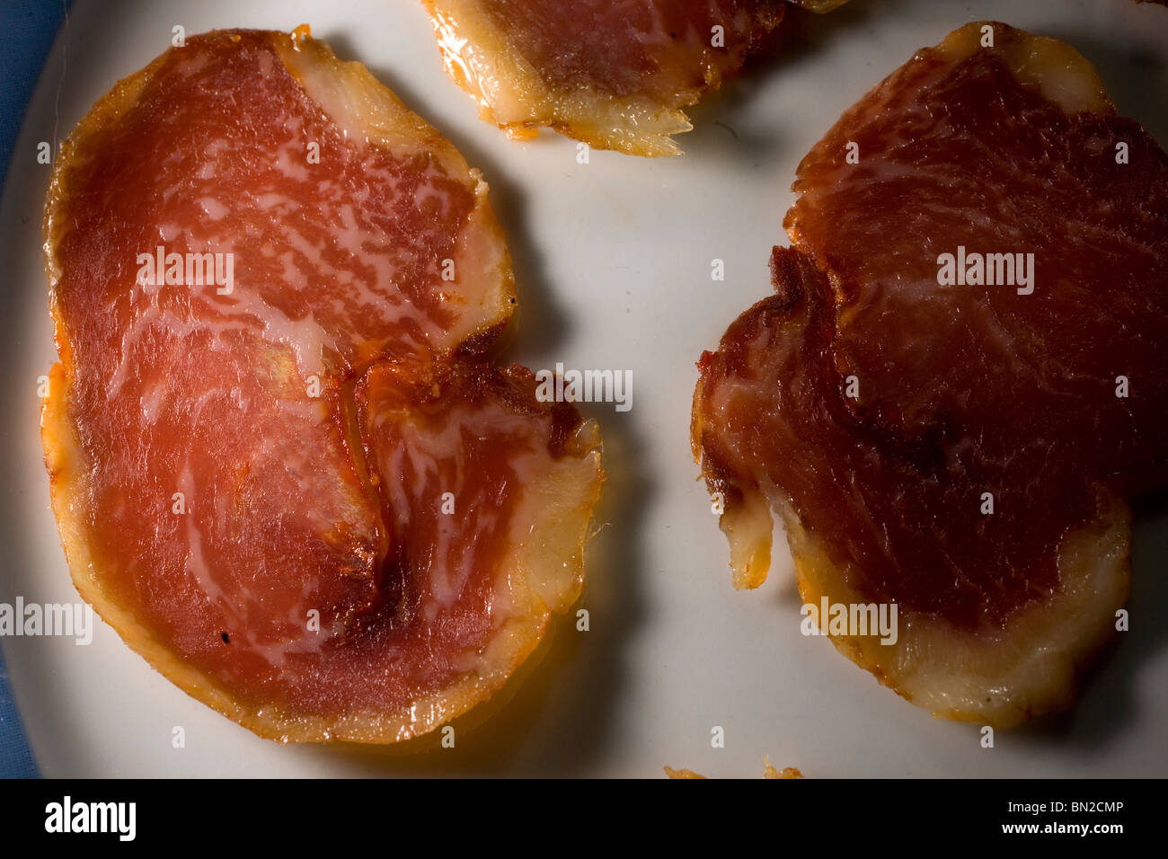 Cured loin slices made from Spanish Iberian pigs sit on a plate in ...